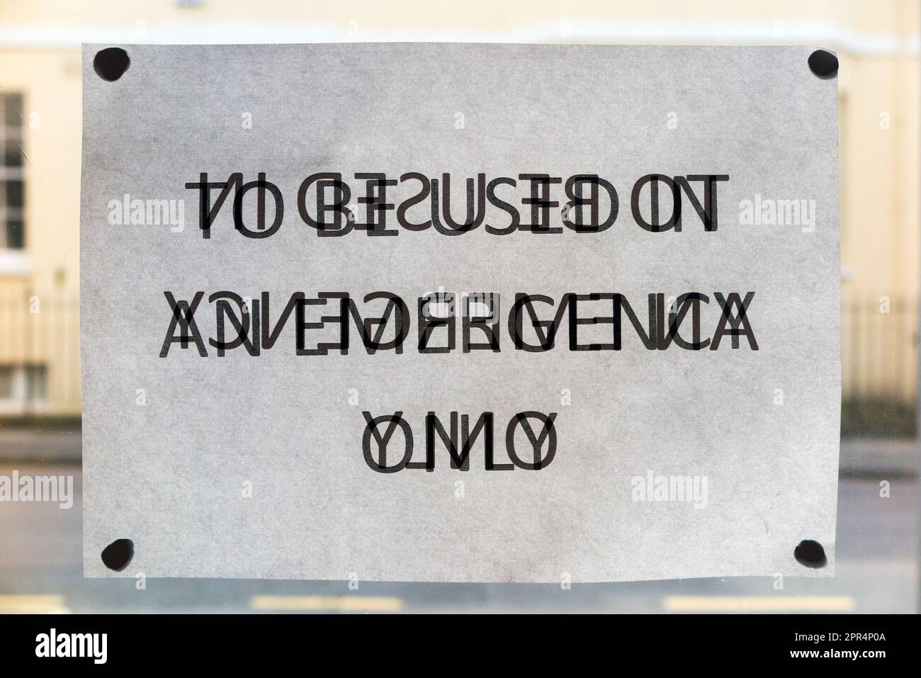 A very confusing emergency sign on a glass door, printed on both sides ...