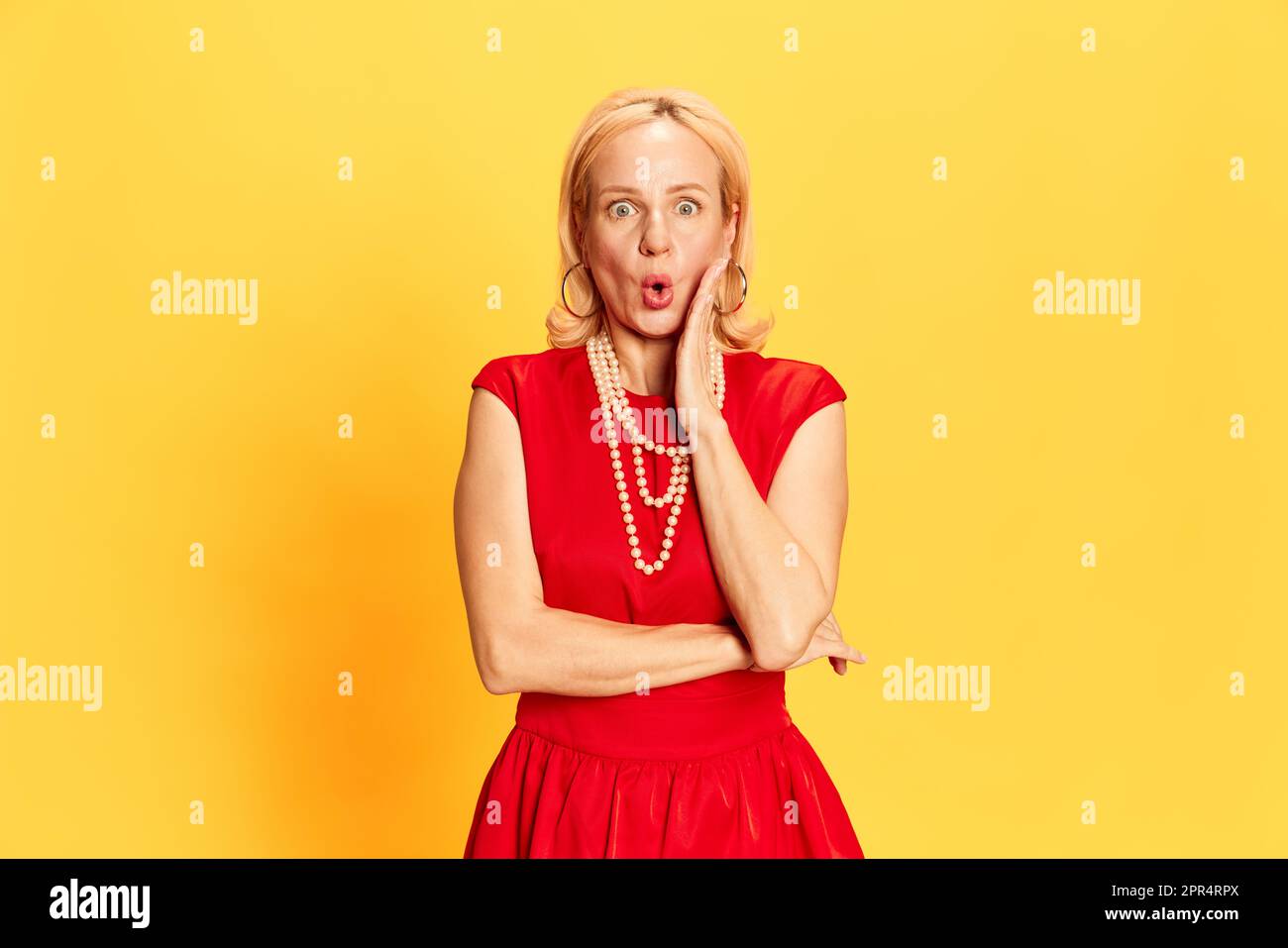 Portrait of blond woman wearing retro clothes looking at camera with ...