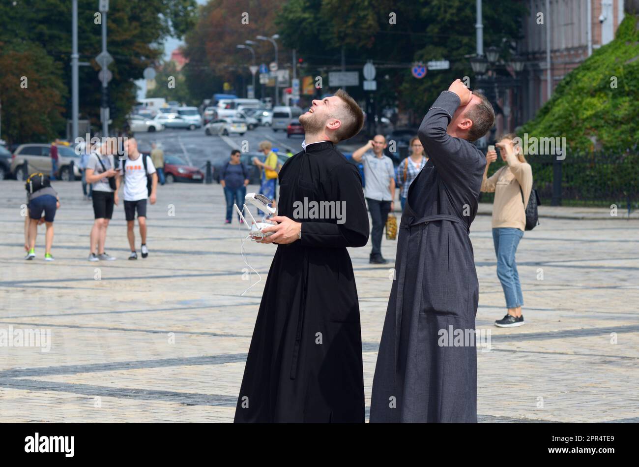 Young men orthodox monks standing on the street looking up managing ...