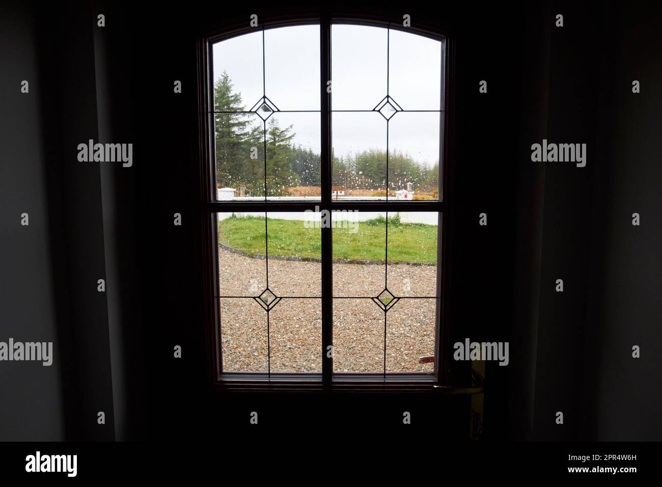 rain drops on the window of a front door looking out from a holiday ...