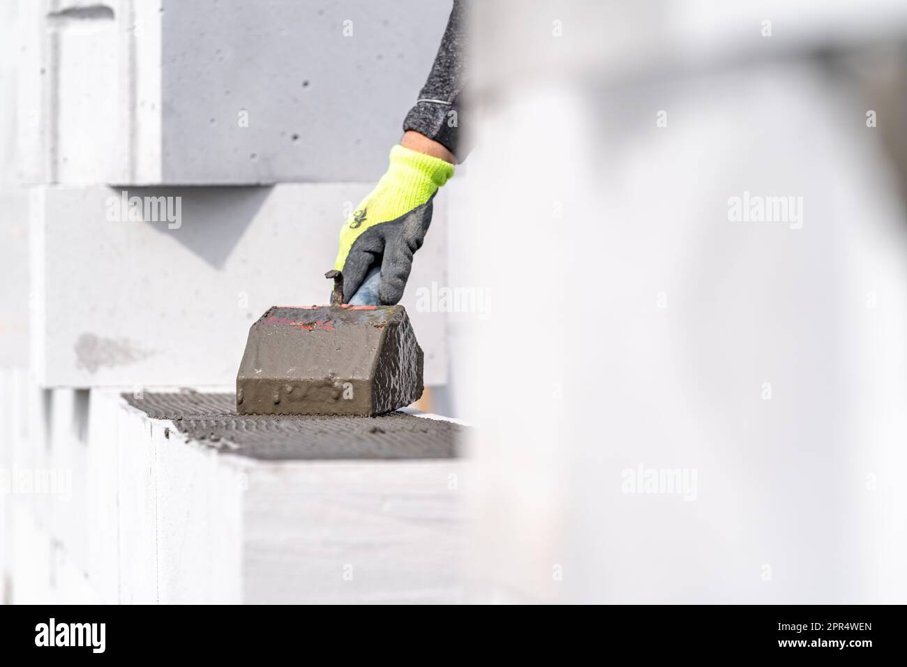 application of cement glue on concrete blocks. construction of a wall ...