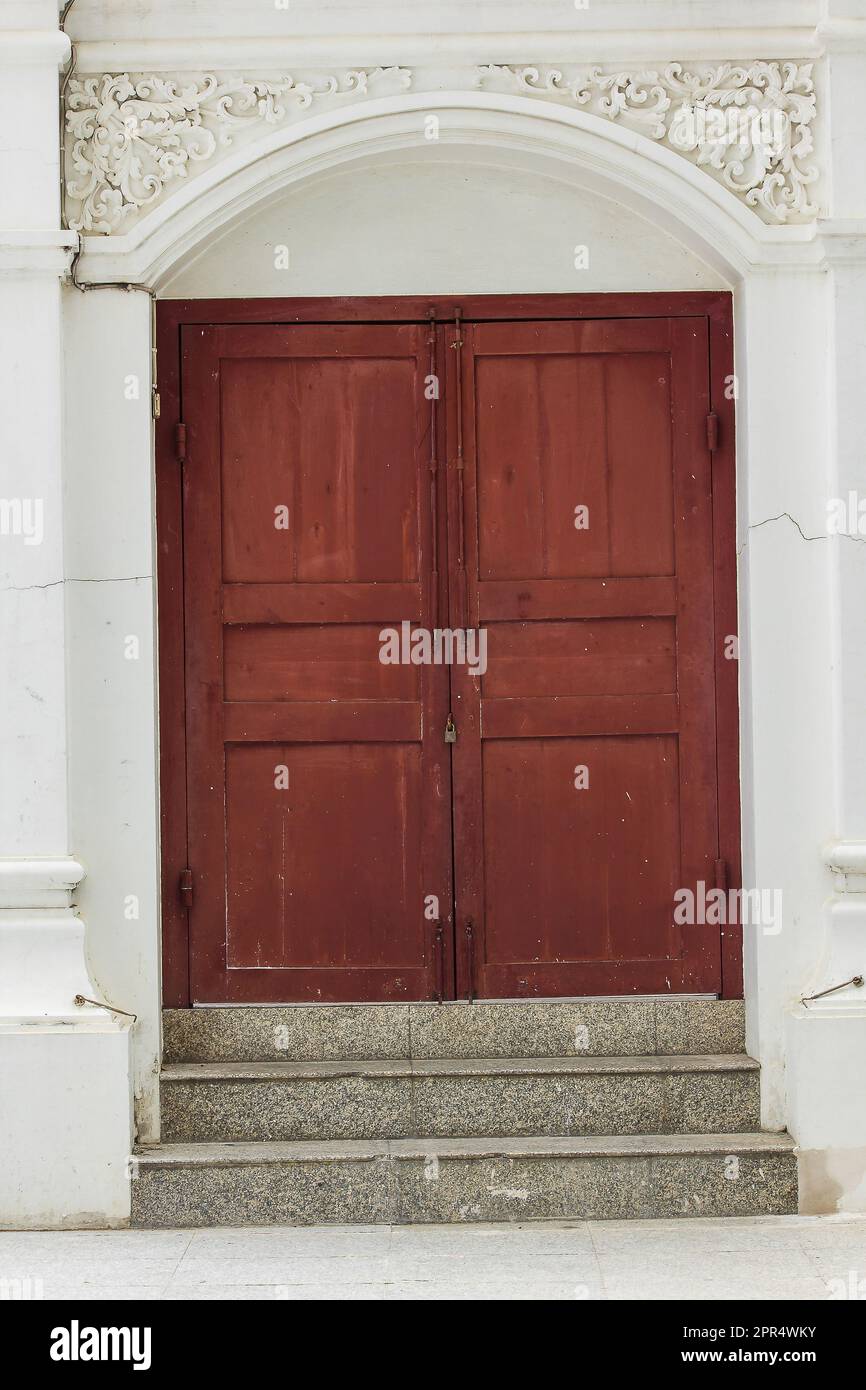 Old brown wood doors on white walls are closed Stock Photo - Alamy