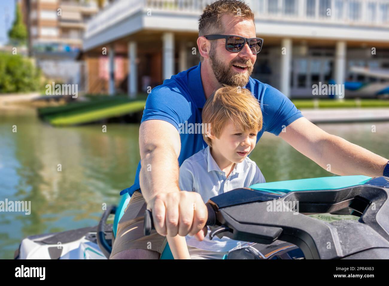 happy, excited family, father and son having fun on jet ski at summer ...