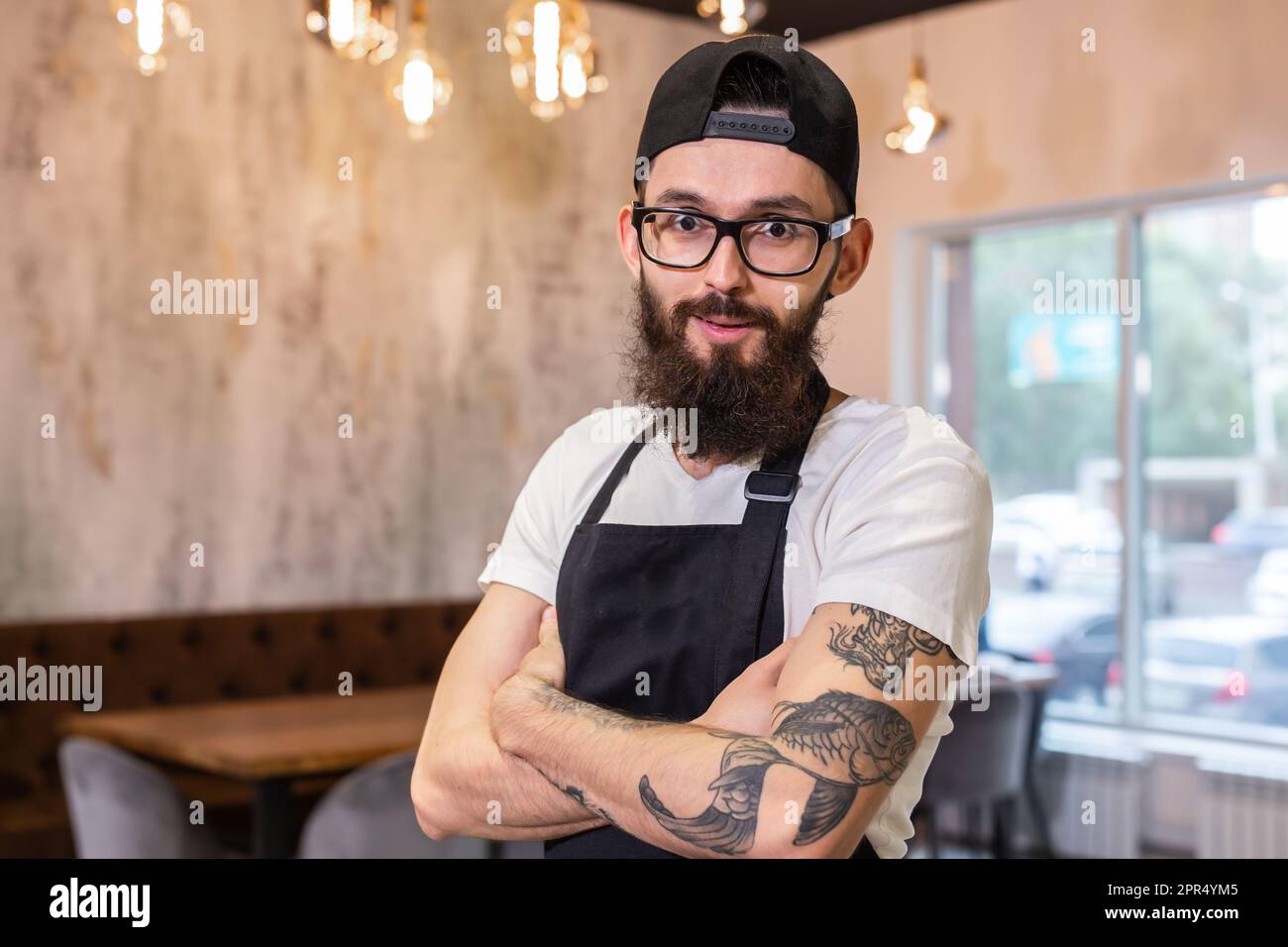 Happy confident young waiter entrepreneur smiling male small cafe business owner employee ...
