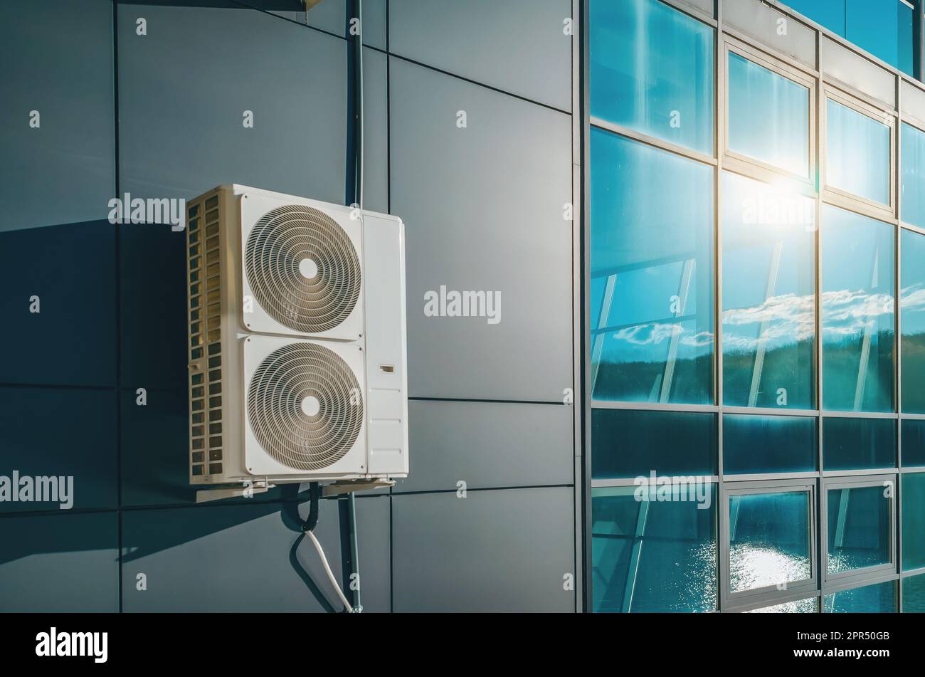 Metal wall of modern building with air conditioning unit. Sun ...