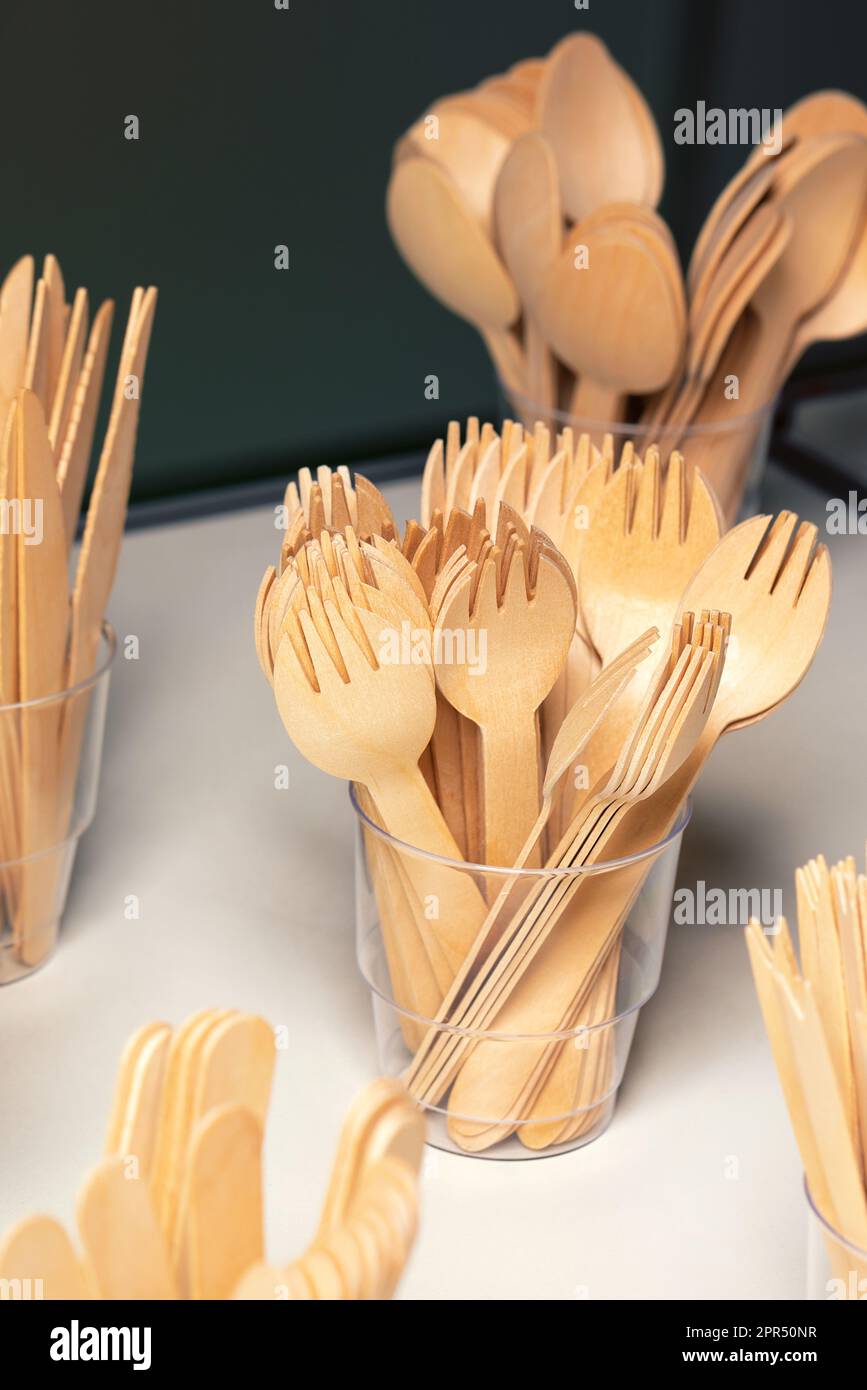 Eco-friendly disposable kitchen utensils. Rounded wooden forks in a ...