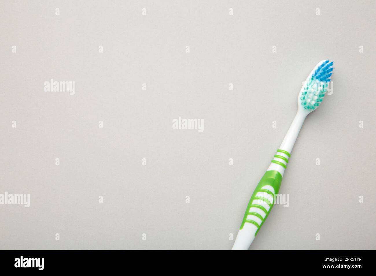 Green toothbrush on a grey background with copy space. Top view Stock ...