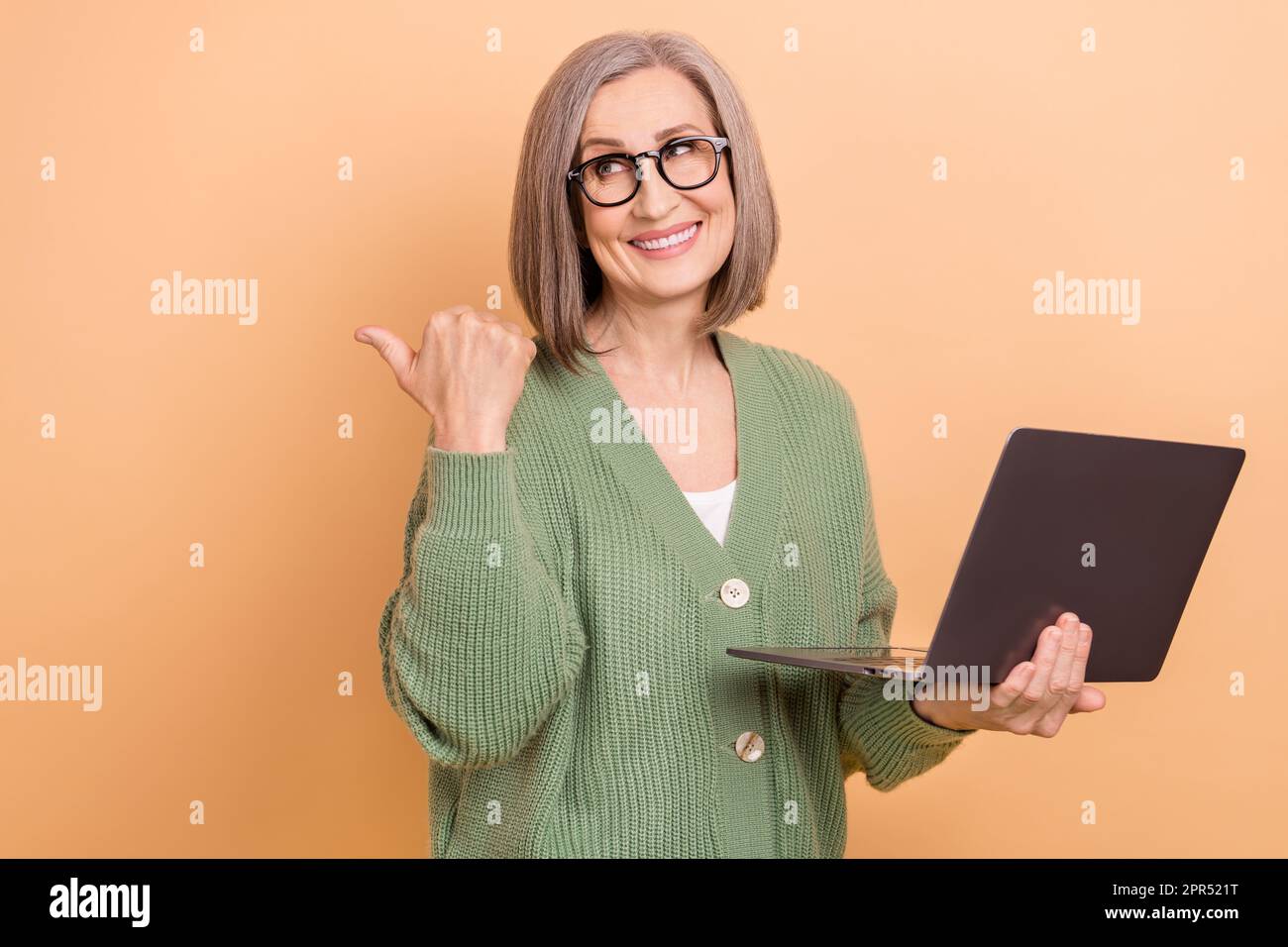 Photo of nice aged lady hold netbook look direct finger empty space ...