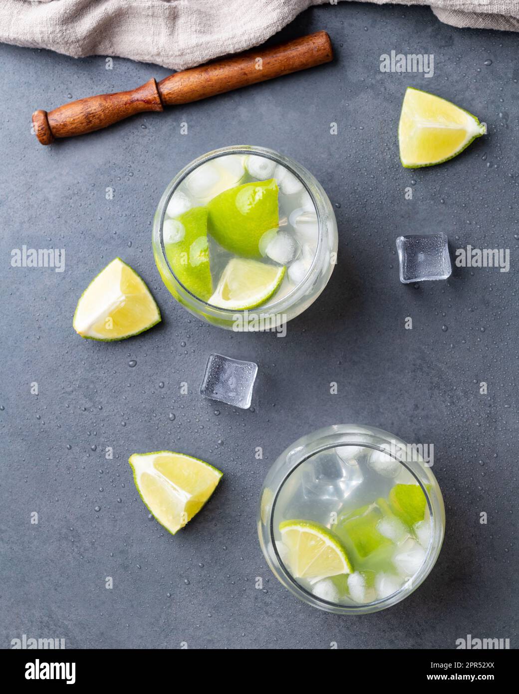 Brazilian lemon caipirinha in glasses with ice and fruit slices over ...
