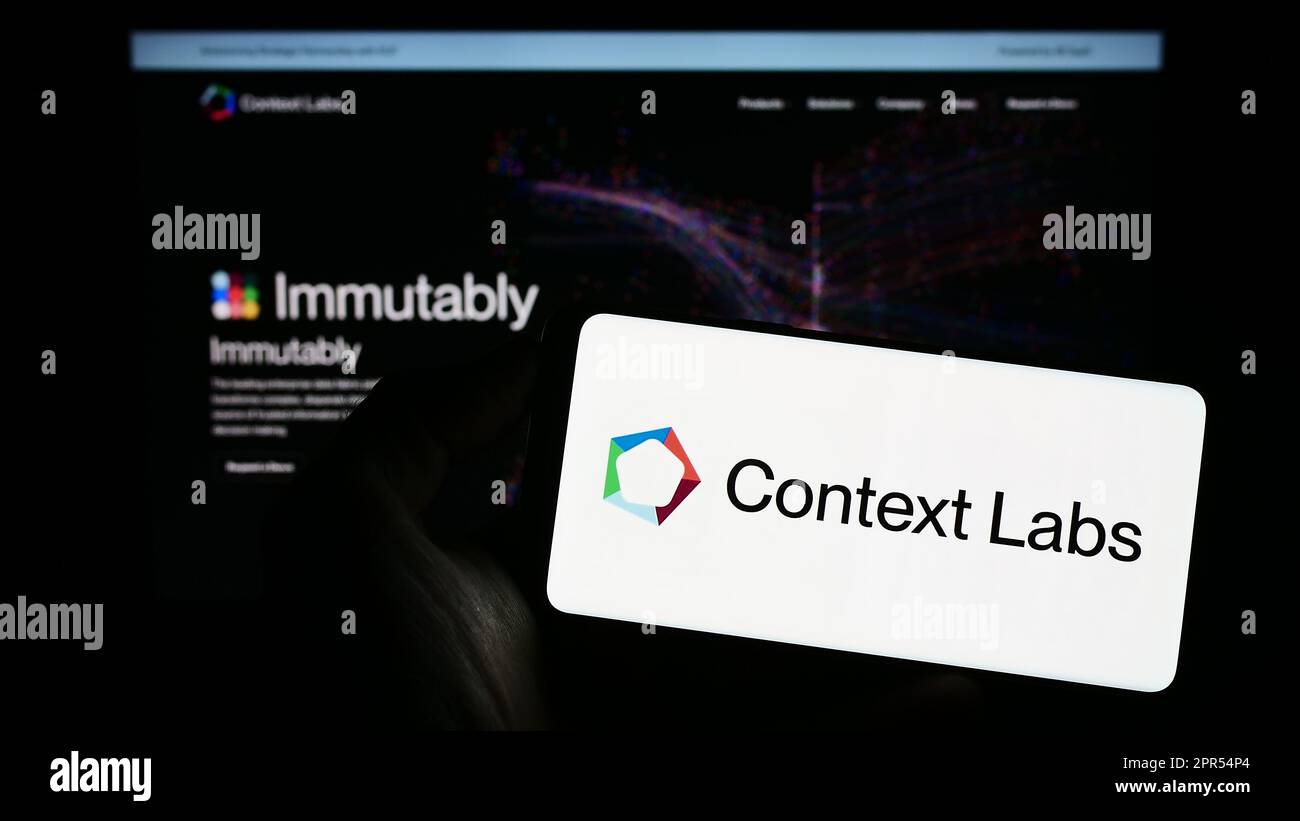 Person holding mobile phone with logo of Dutch blockchain company Context Labs B.V. (CXL) on ...