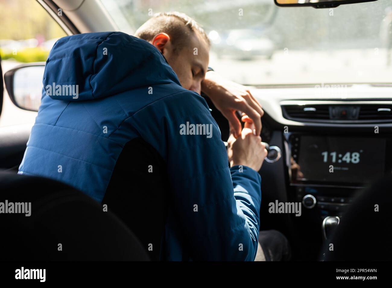 A young Asian man sleeping in his car, and he not driving for the ...
