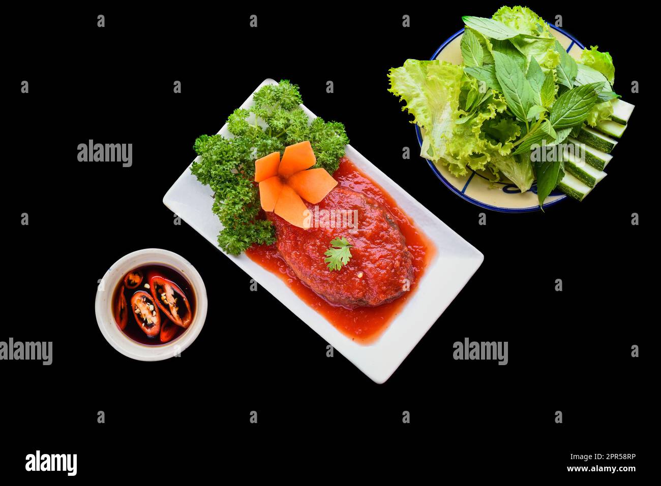 Vietnamese stewed sapa fish in red sauce isolated on black bacground ...