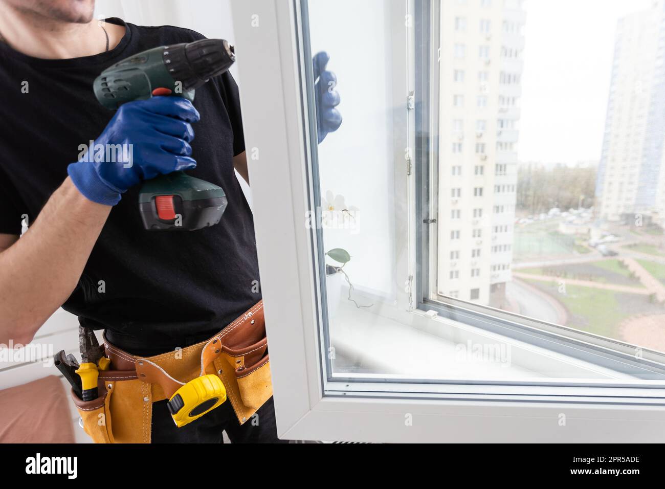 Worker adjusting installed window with screwdriver indoors, closeup ...