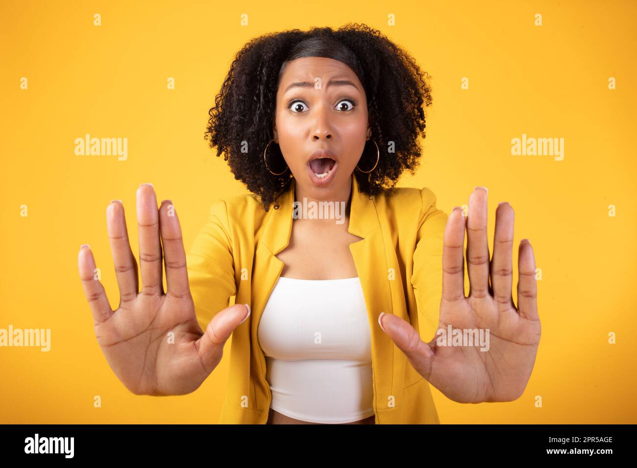 Shocked black lady showing stop gesture at camera, refusing something ...