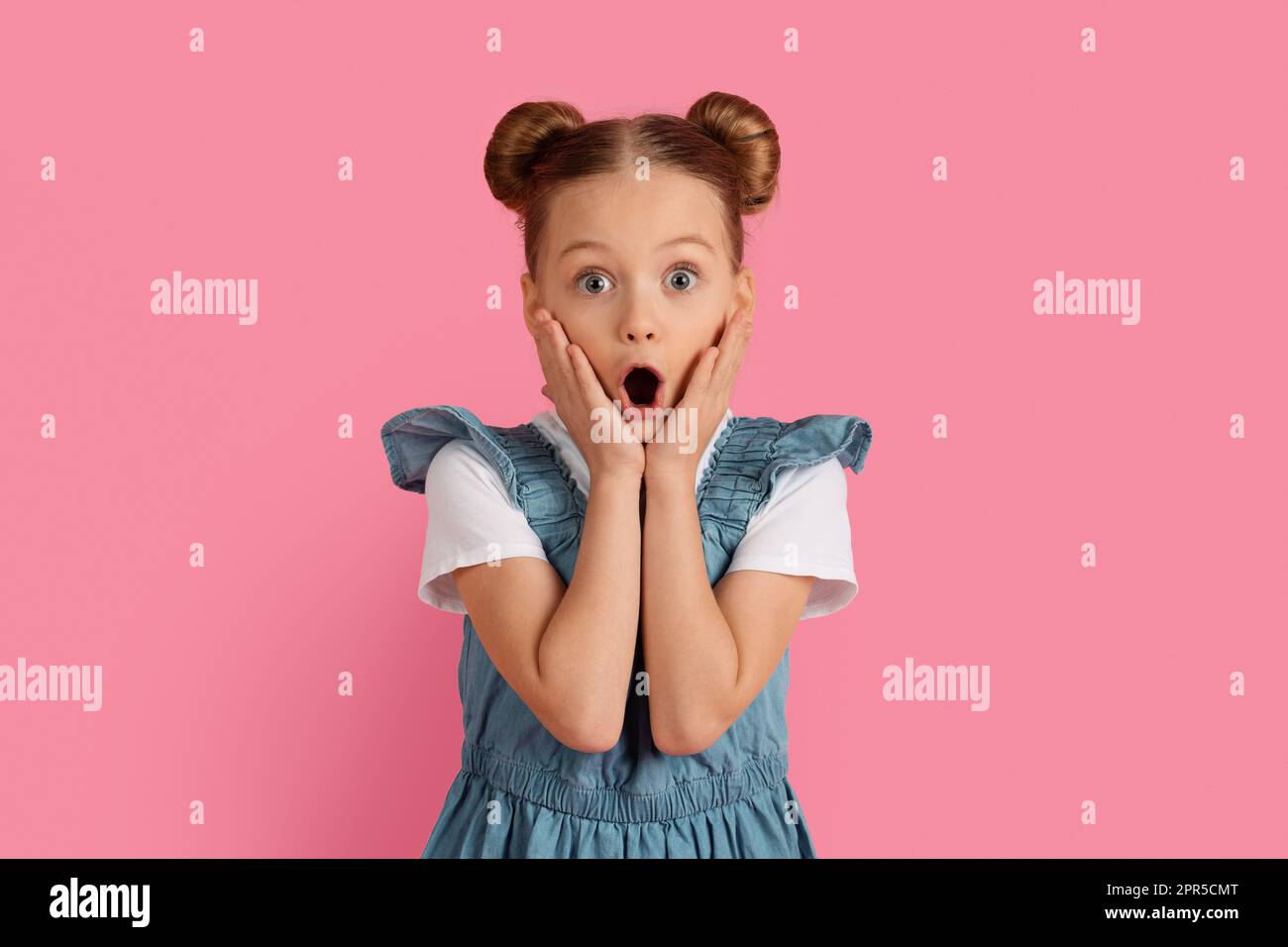 Portrait Of Shocked Little Girl Touching Face And Looking At Camera ...