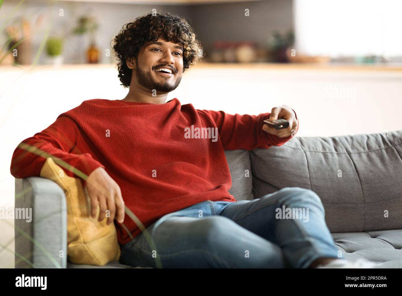 Weekend Pastime. Cheerful Indian Guy Watching Tv At Home, Holding ...