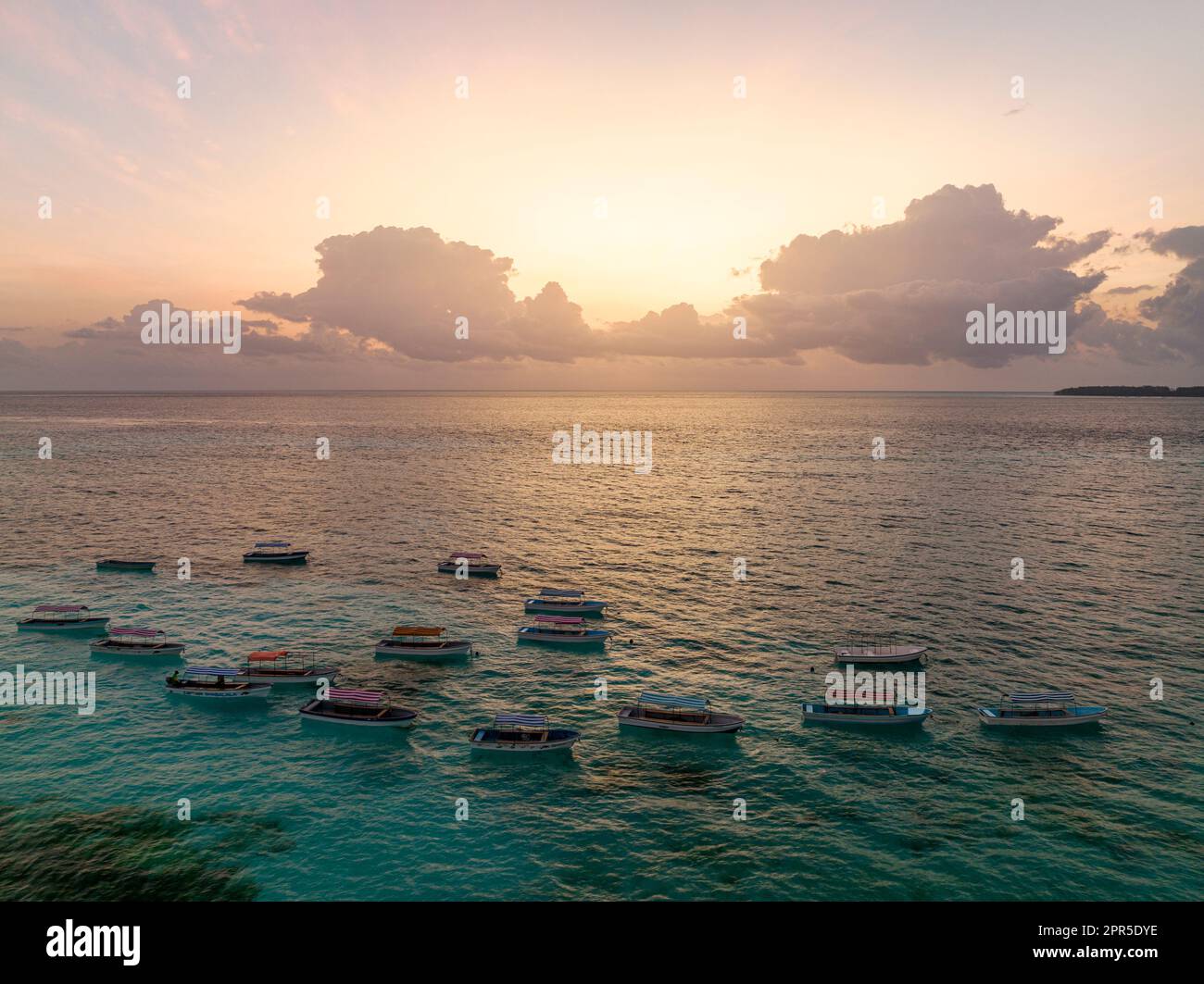 Boats moored in the crystal sea at sunset, Zanzibar, Tanzania Stock ...