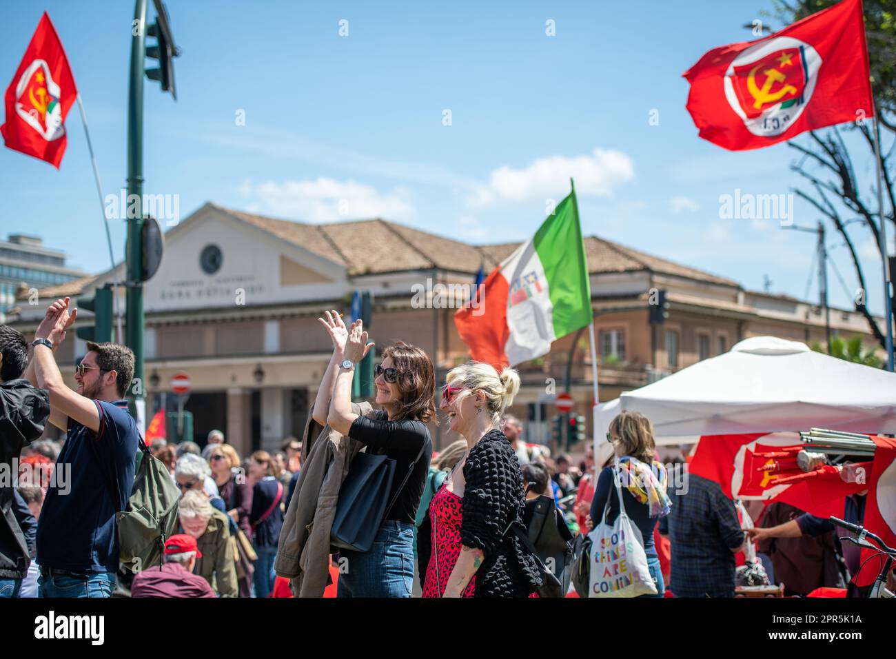 Two women laugh happily while one applauds between the flags of the ...