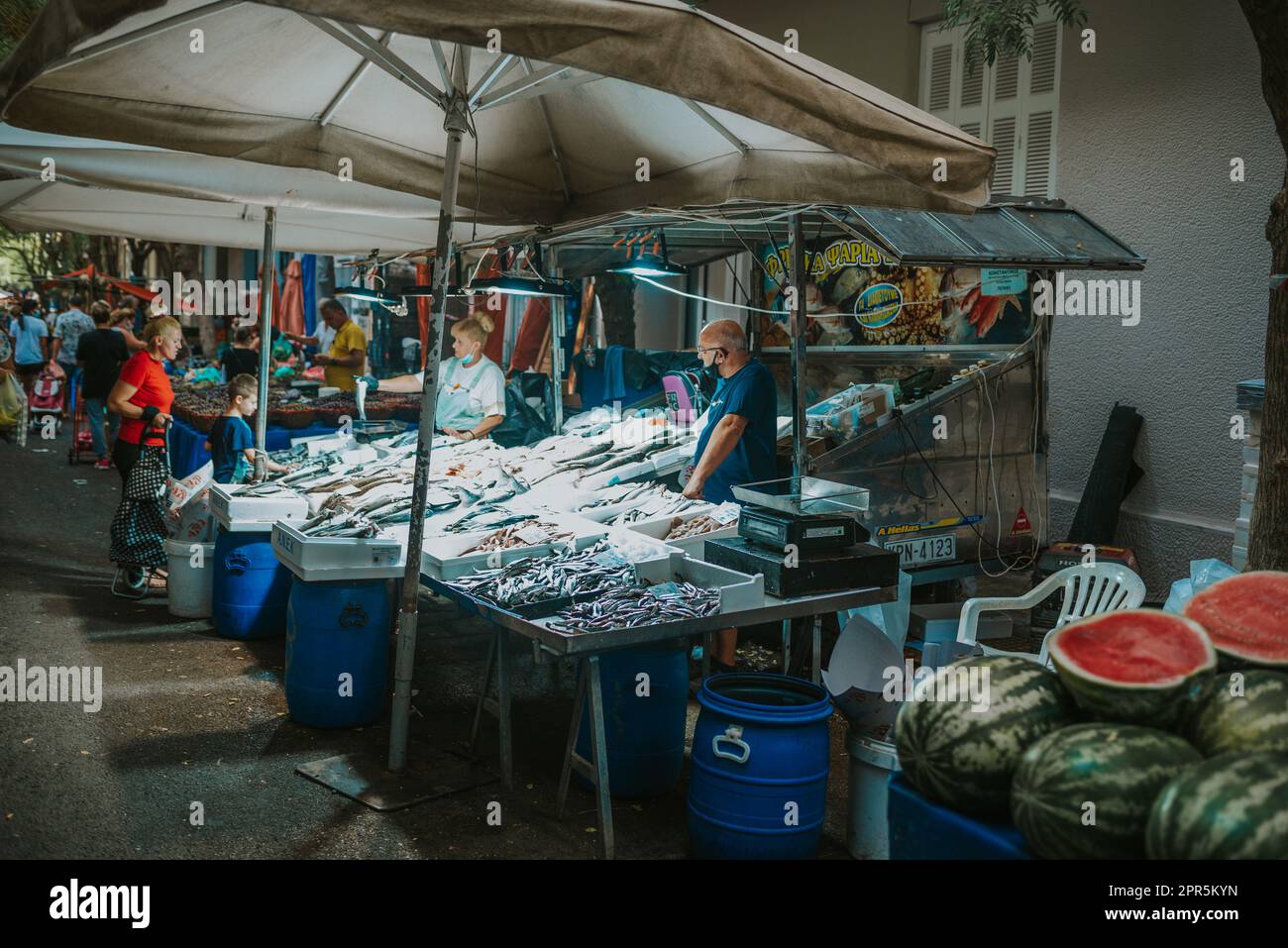 Fish monger sells catch of the day fish under flourescent lights at ...