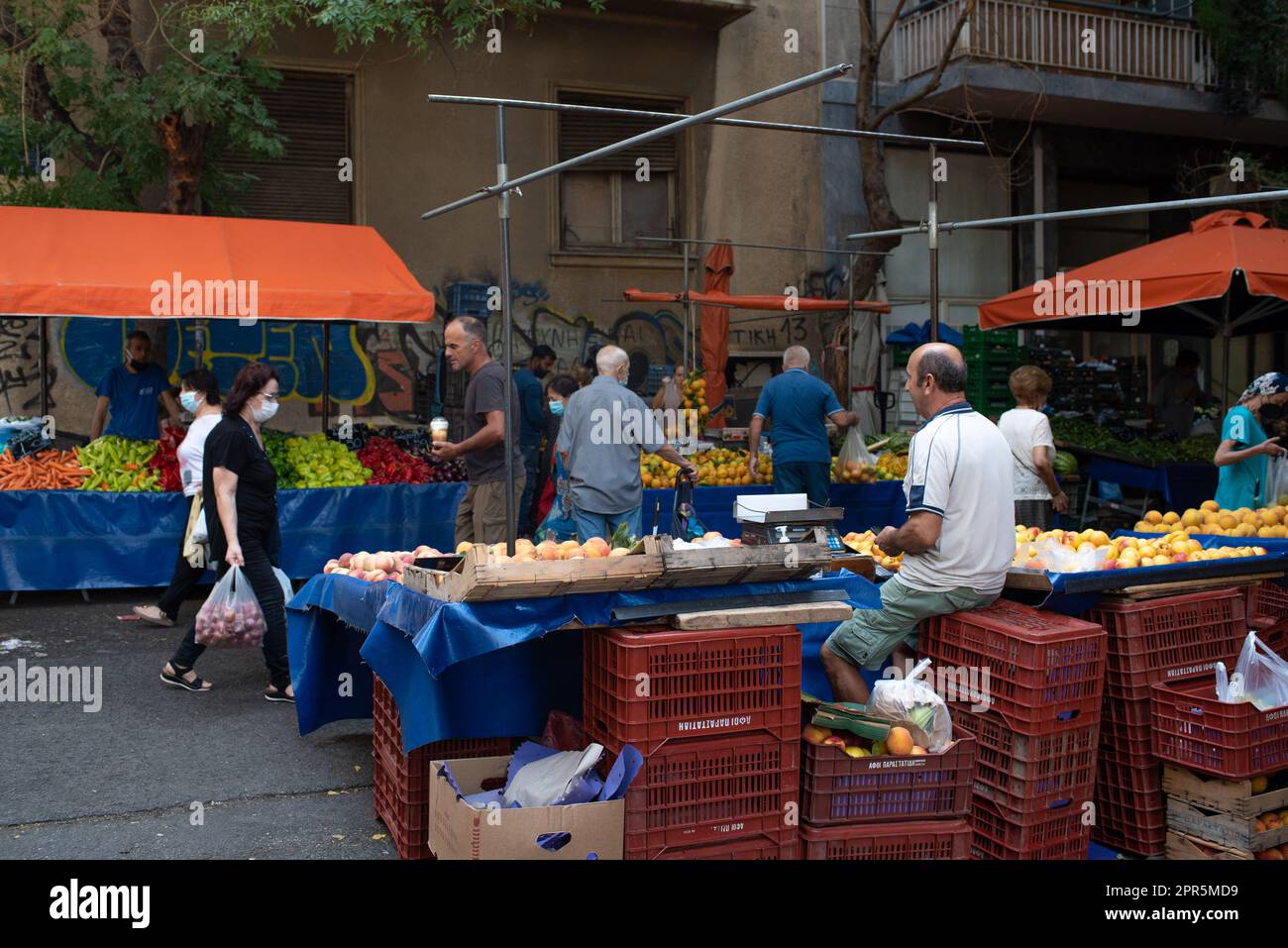 Greek Farmer's Market vendor sits on crates waiting for business Stock ...