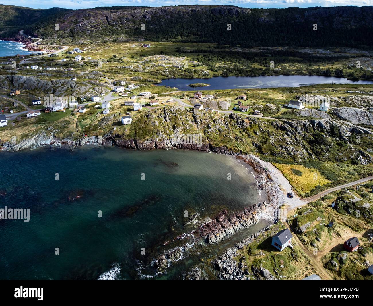 Aerial winding road into Newfoundland small community with boat dock ...