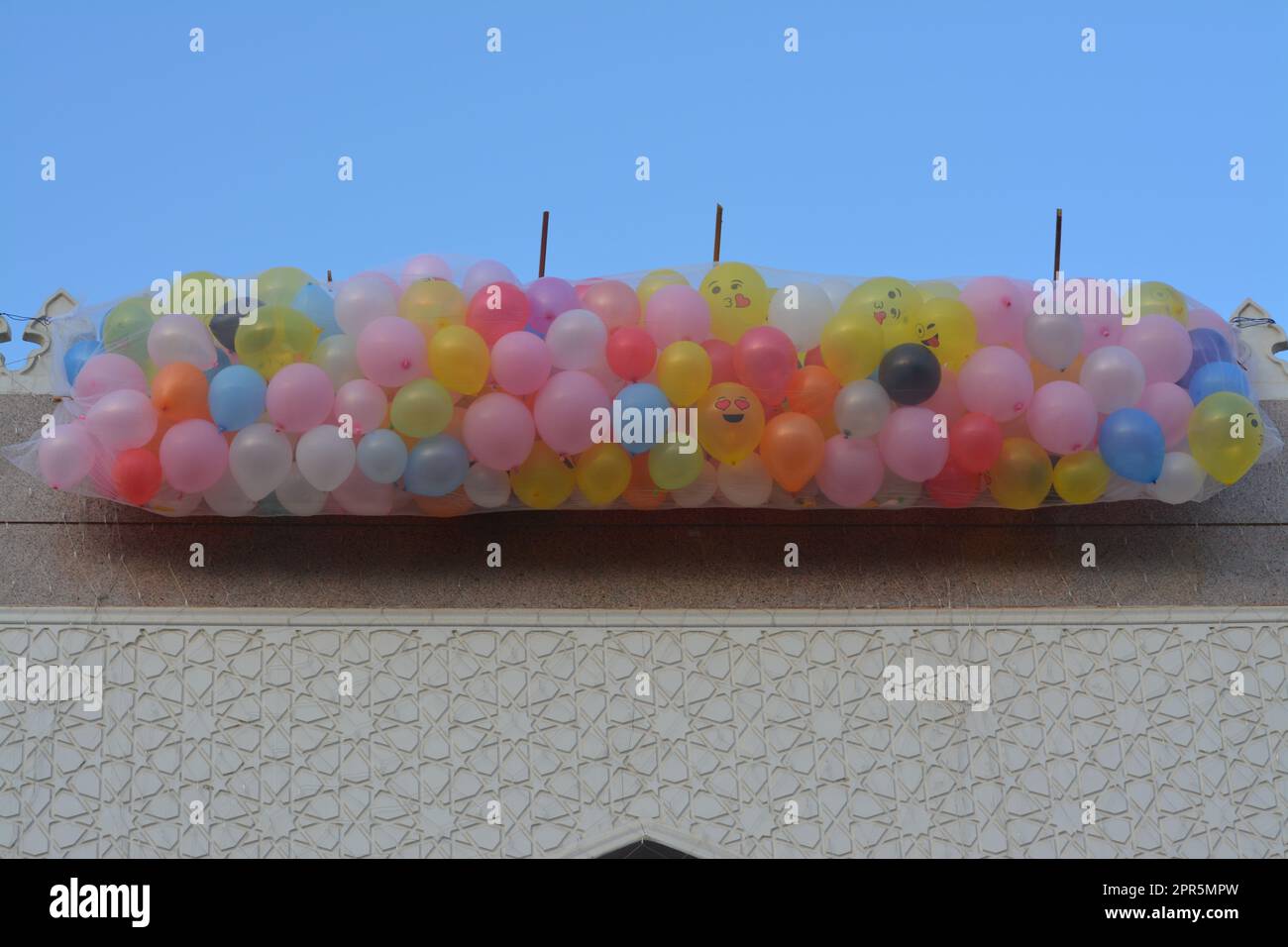 Background of festive and celebrations outside a mosque in Cairo Egypt with tens of balloons ...