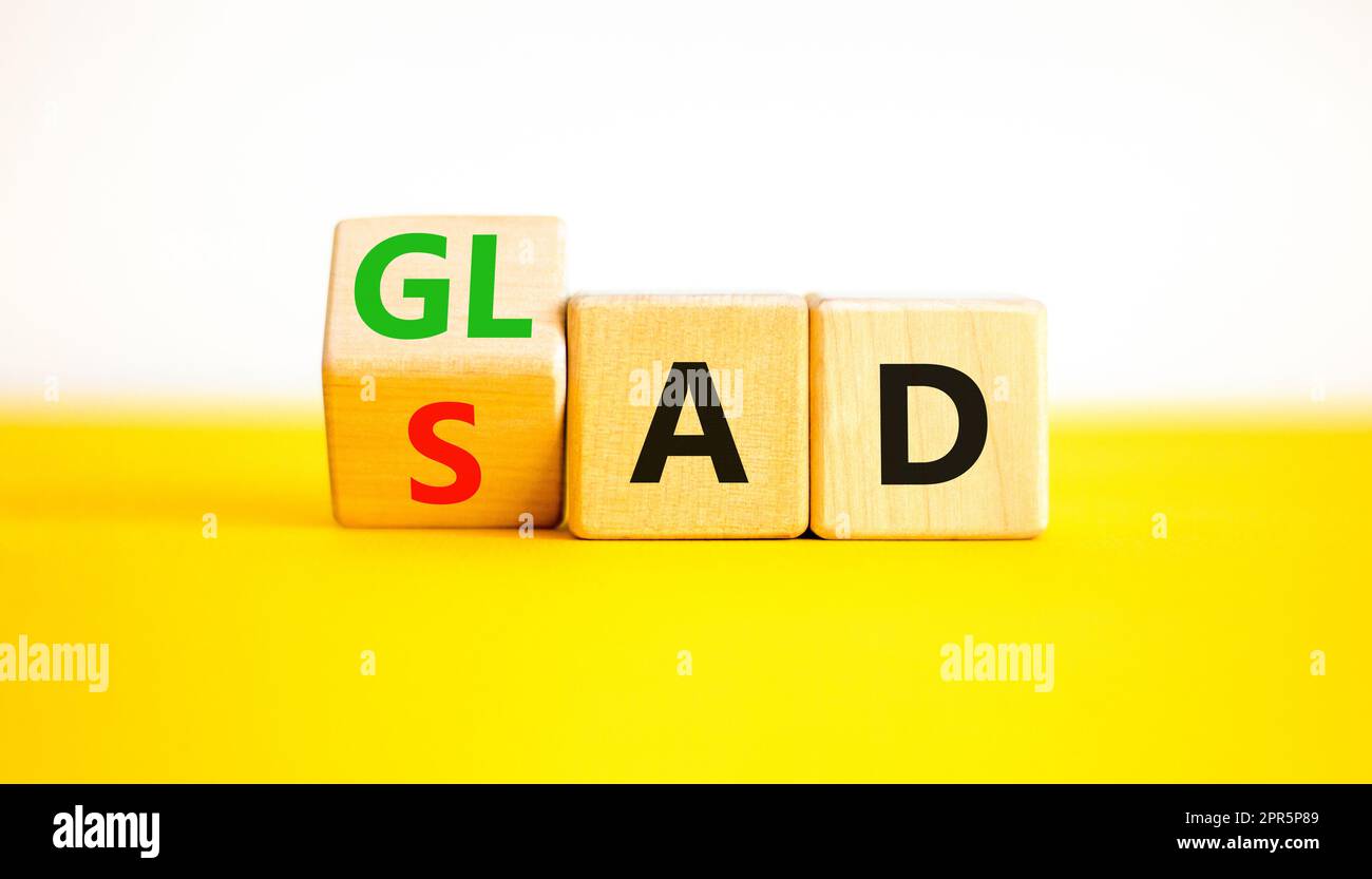Glad or sad symbol. Businessman turns wooden cubes and changes the word ...
