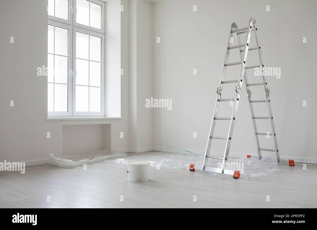 Empty interior with white freshly painted walls, step ladder, and a ...