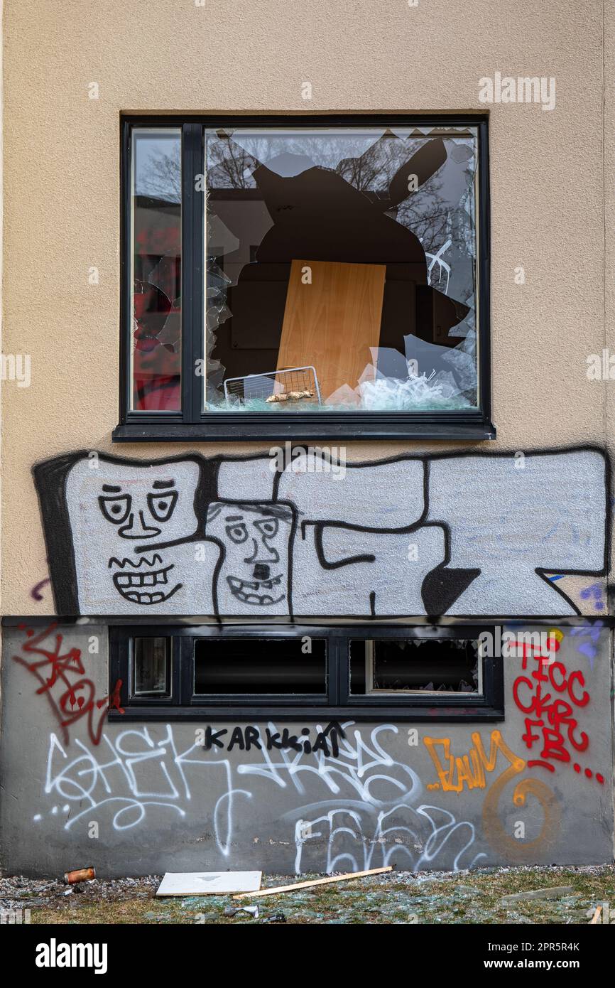 Graffiti covered abandoned residential building with broken window ...