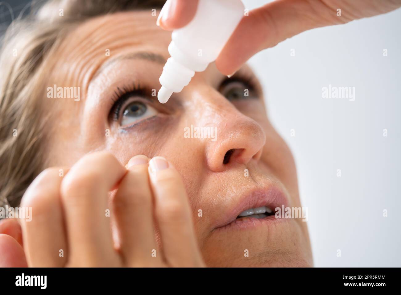 Young Woman Putting Eye Drops In Her Eyes Stock Photo - Alamy