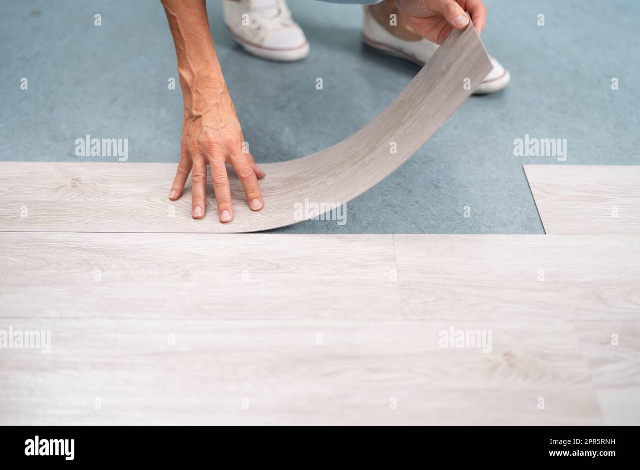 Installing New Vinyl Laminate. Woman Fixing Floor Stock Photo - Alamy