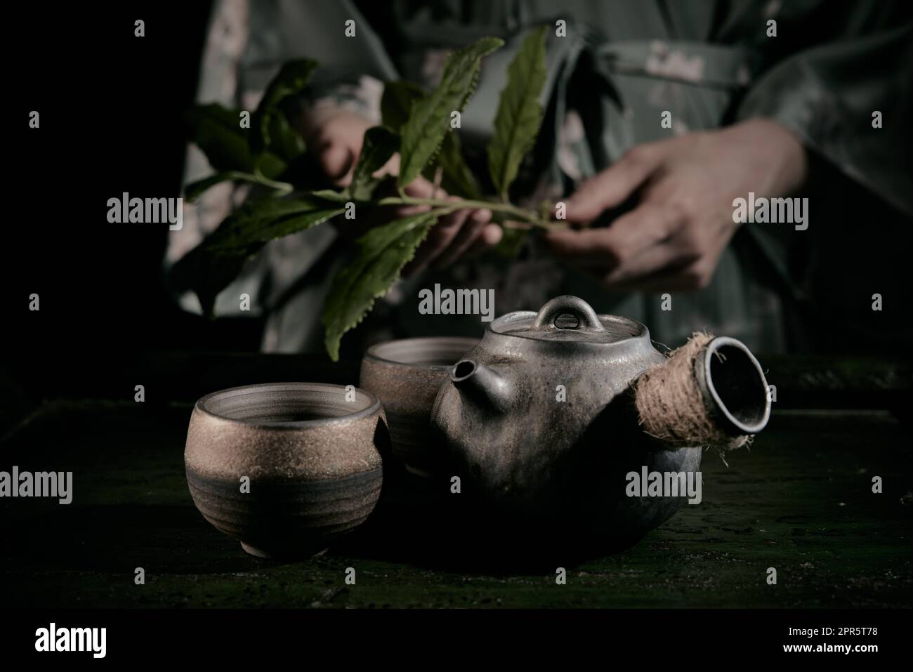 Anonymous person with tea leaves near old tea set Stock Photo - Alamy