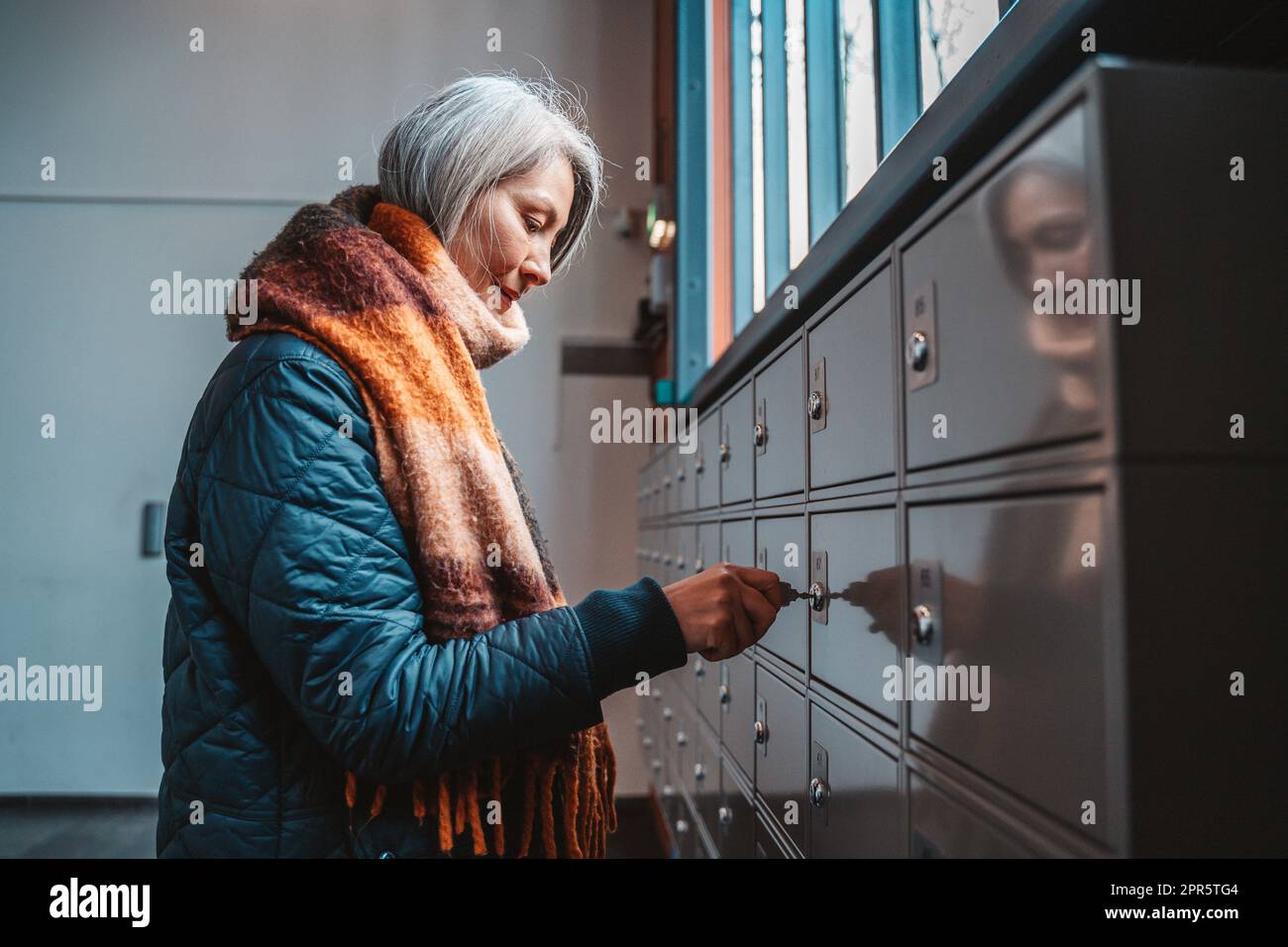 Senior woman opens the mailbox to check for new mails Stock Photo - Alamy