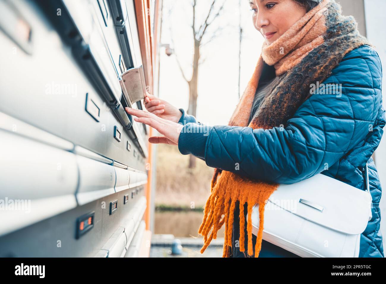 Senior woman opens the mailbox to check for new mails Stock Photo - Alamy