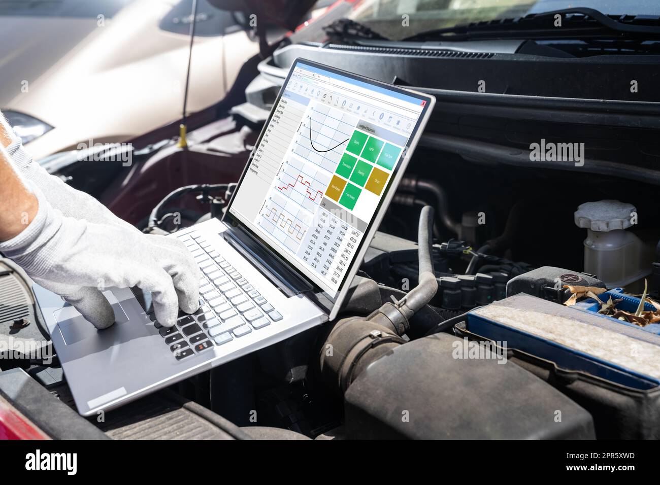 Mechanic With Laptop While Examining Engine Stock Photo - Alamy