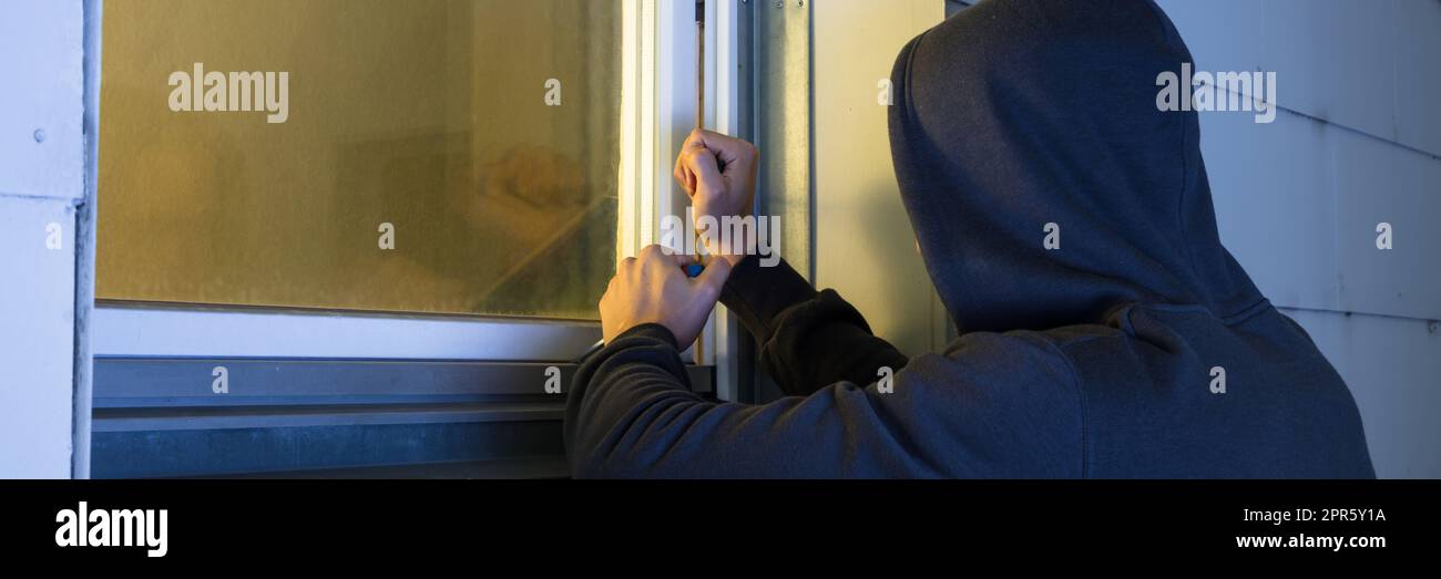 Robber Using The Crowbar To Open The Glass Window Stock Photo - Alamy