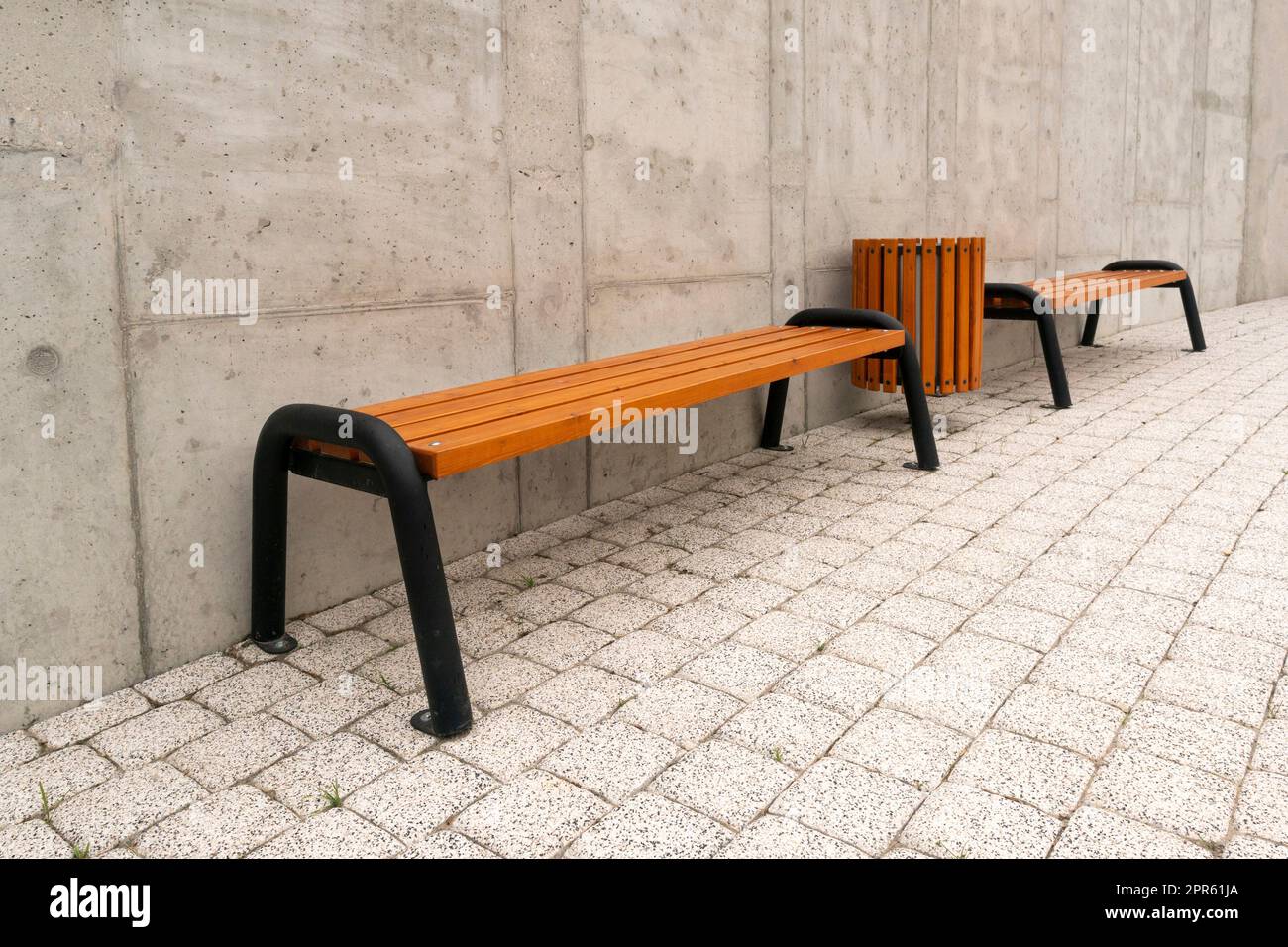 Two wooden benches and garbage bin Stock Photo - Alamy