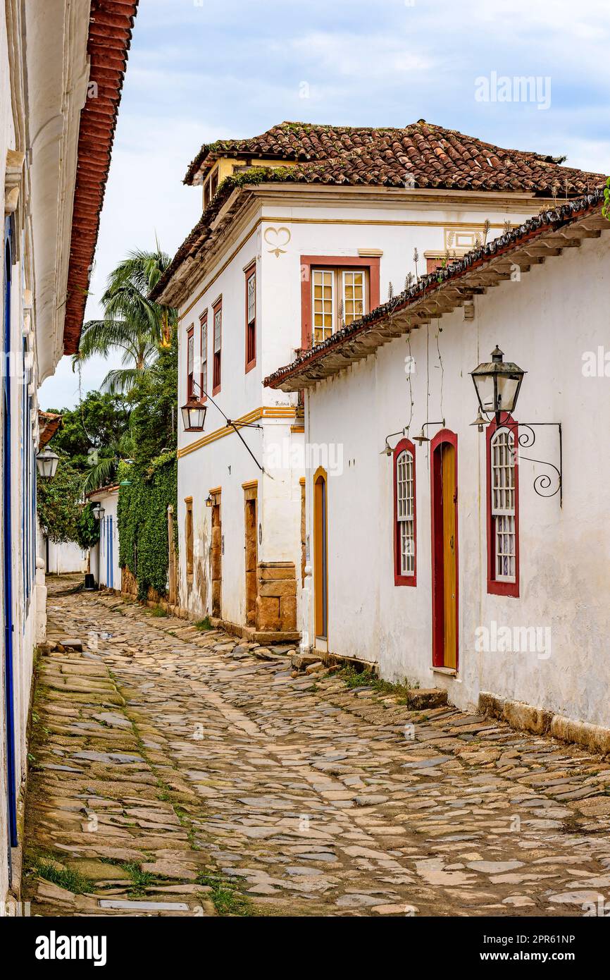 Bucolic street with old colonial-style houses and cobblestone pavement ...