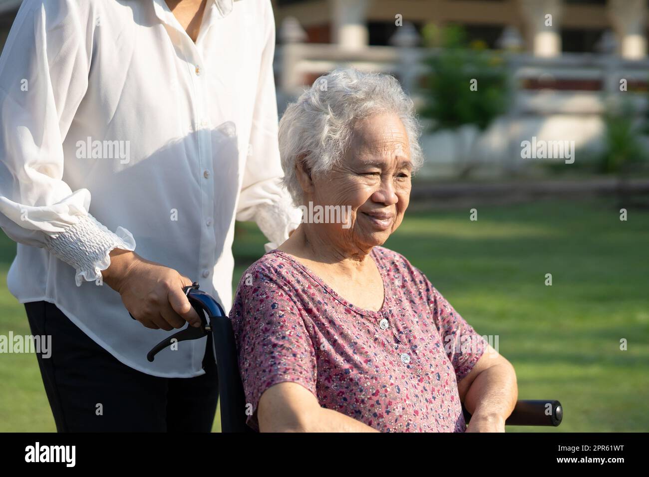 Caregiver help and care Asian senior or elderly old lady woman patient ...
