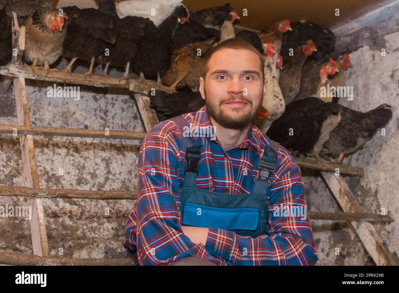 A smiling handsome farmer with a beard, Caucasian, in overalls and a ...