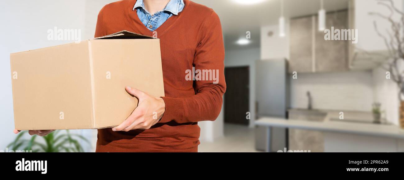 young delivery man standing with parcel post box Stock Photo - Alamy