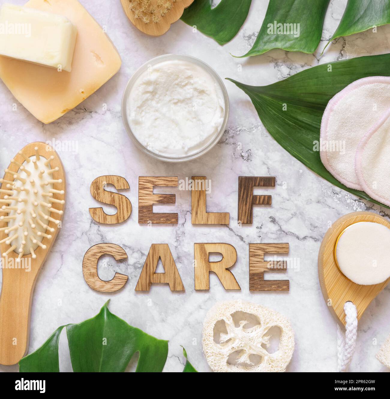 Self Care text near cosmetics, skincare accessories and monstera leaves ...