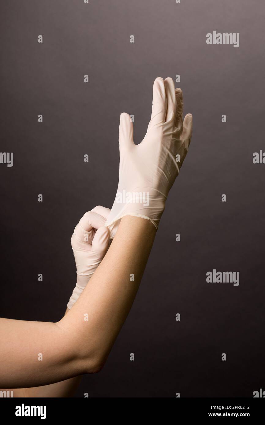 Putting on latex gloves Stock Photo - Alamy