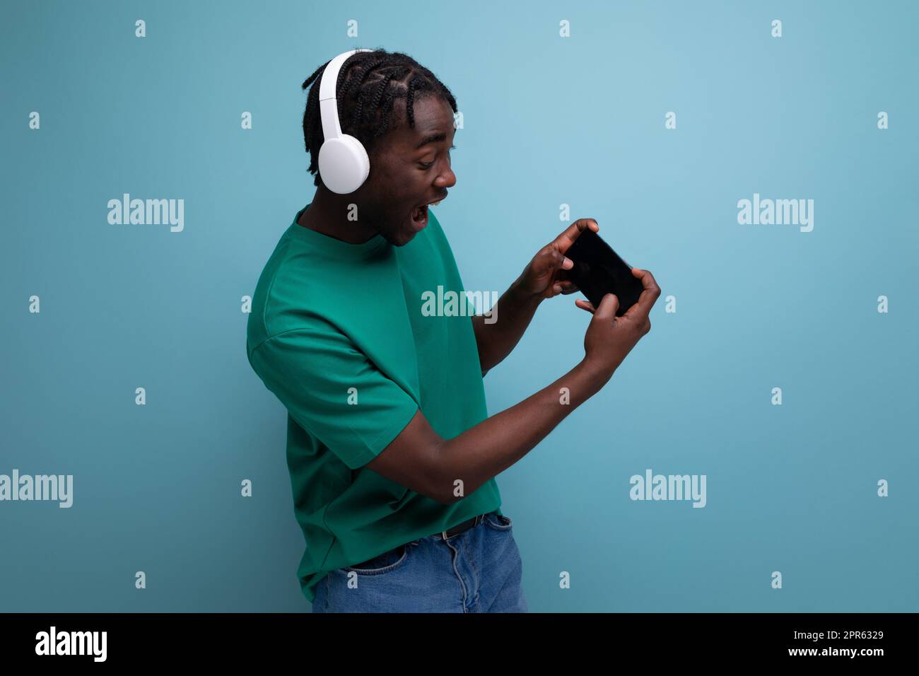 african gamer man with wireless headphones and powerful smartphone ...