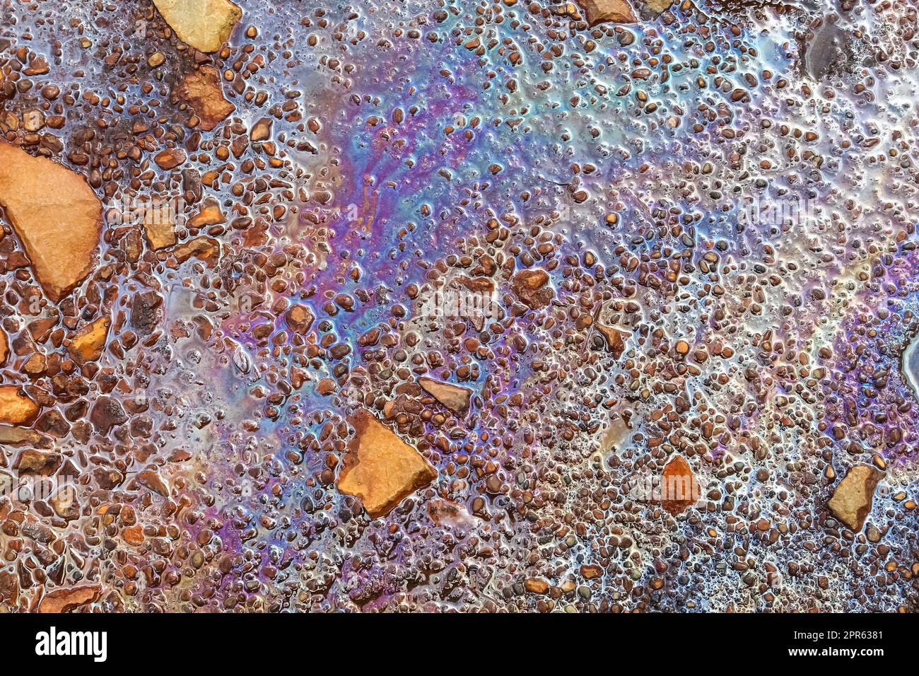 Colorful fuel and oil on an asphalt texture showing heavy enviromental ...