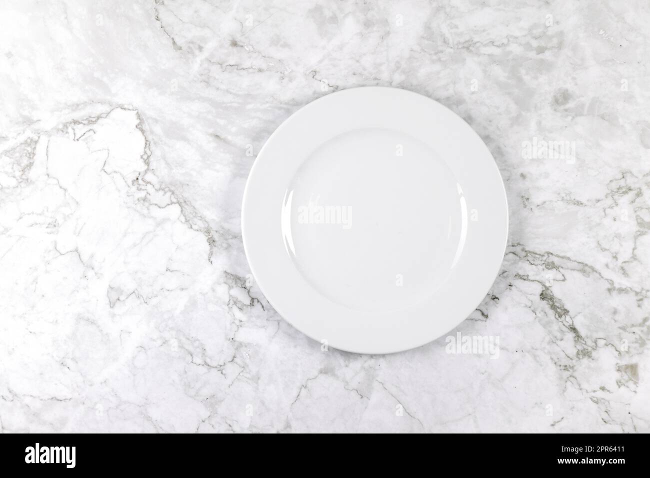 Dinner plate on a white and grey marble surface Stock Photo - Alamy