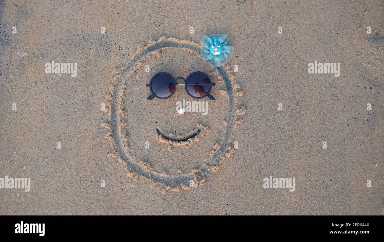 A decorated face drawn on the beach Stock Photo - Alamy