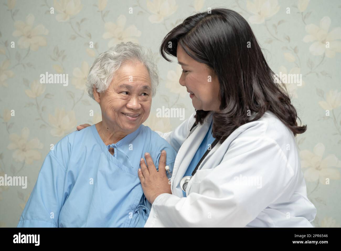 Doctor using stethoscope to checking the patient sit down on a bed in ...