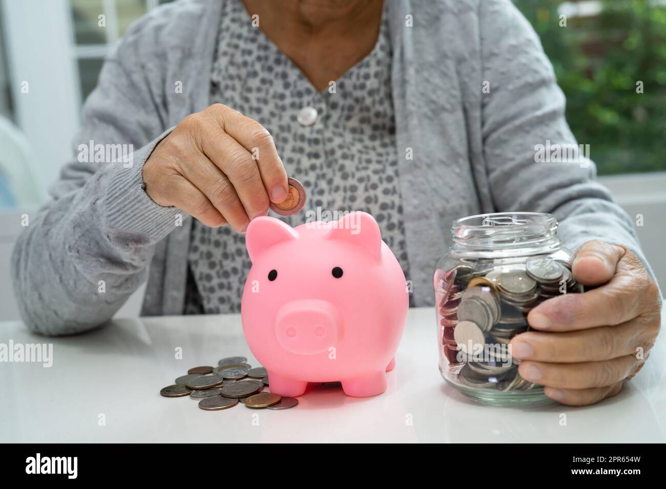 Asian senior or elderly old lady woman holding counting coin money in ...