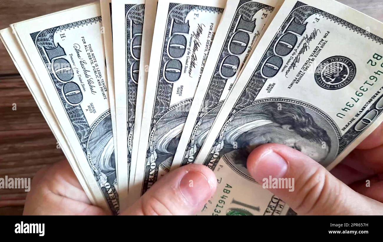 A photo of dollar bills in the hand of a man Stock Photo - Alamy